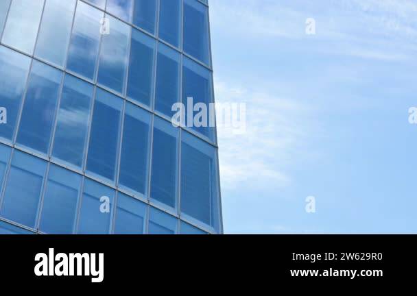 Sky and clouds reflecting in the windows of a modern glass skyscraper ...