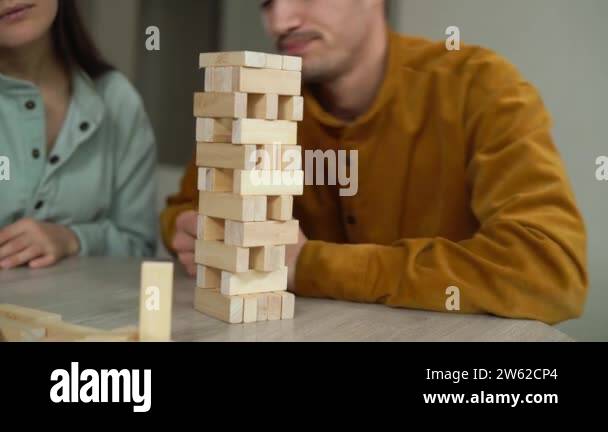 a man and a woman are playing Jenga. Educational board games for the ...