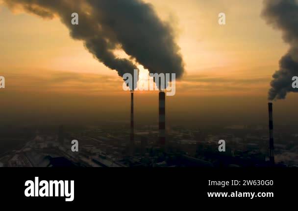 Power Plant emissions seen above the city during sunrise. Environmental ...