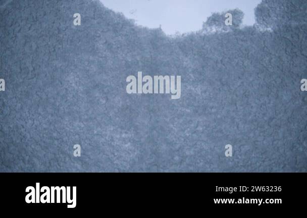 The process of melting snow on a car windshield. The melted snow and ...