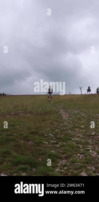 young active man runs down a steep hill. An athlete is running downhill ...