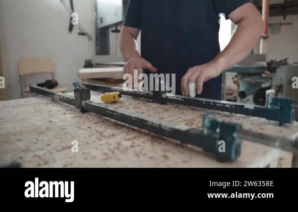 Professional carpenter using industrial ruler for measuring length of ...