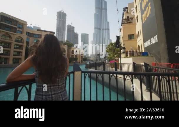 Woman watching Burj Khalifa skyscraper from the balcony in Dubai ...