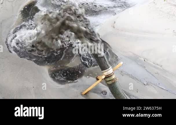 Close-up big pipe of power pump machine pouring mud sludge waste water ...