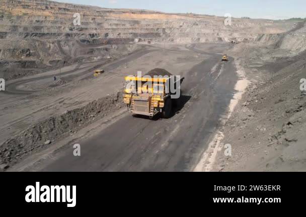 Large quarry dump truck. Loading rock in dumper. Loading coal into truck. Mining car machinery ...