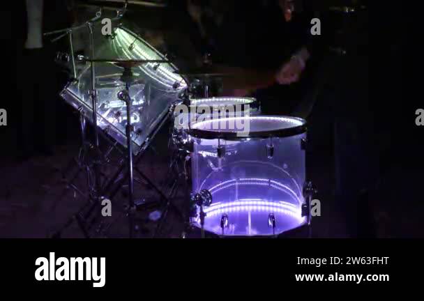 Artists play glowing drums at the festival. The reels are flashing with ...