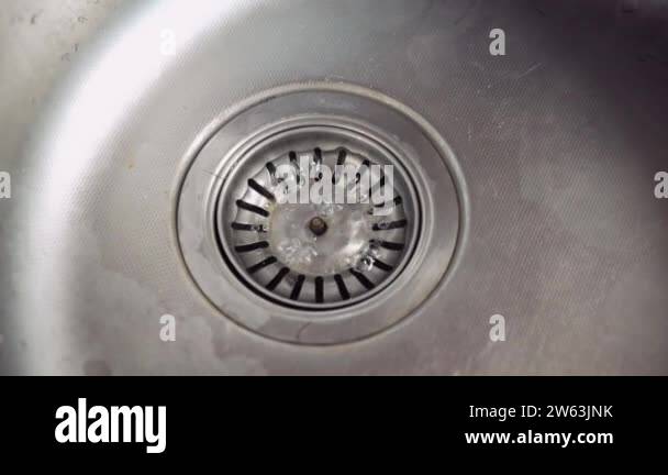 A blockage in the pipe, dirty water coming from the silver steel sink ...