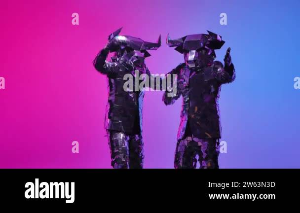 Two people in futuristic costumes of bulls from the mirrors cheerfully ...