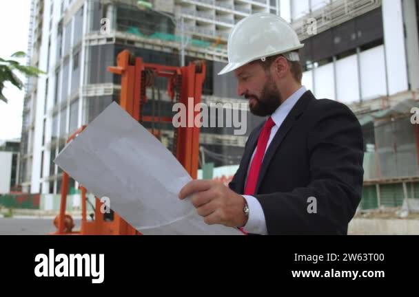 An engineer, a developer at a construction site, checks the drawings ...