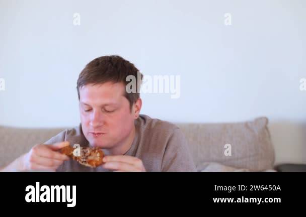 A man eats unhealthy foods with appetite. Foods high in carbohydrates ...