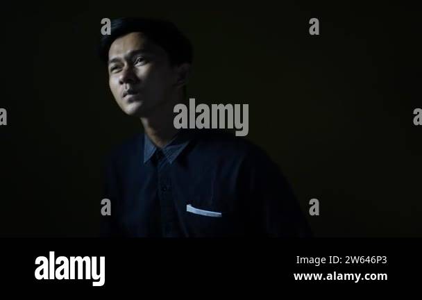 portrait of an asian man drinking coffee in a dark room. the concept of ...