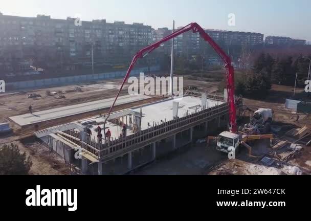 Aerial of concrete boom pump crane arm truck with outriggers pouring ...