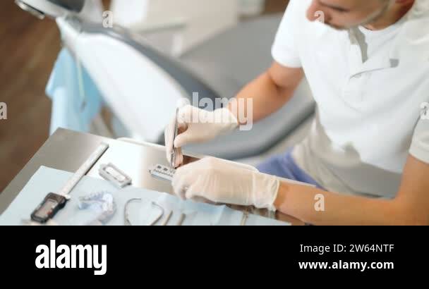 Orthodontist working with jaw model applying brace system Stock Video ...