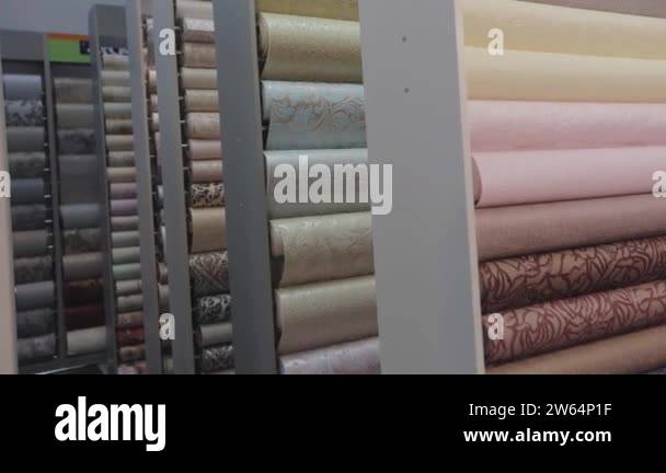 Stands with rolls of wallpaper samples in the store. Stands with new ...
