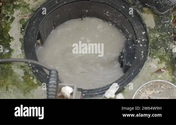 Drain cleaning. Plumber repairing clogged grease trap with auger ...