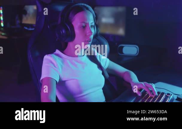 Young concentrated gamer woman sits at the computer in the gaming club ...