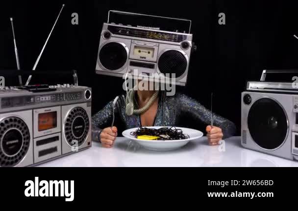 Woman with ghettoblaster as a head eating cassette tape Stock Video ...