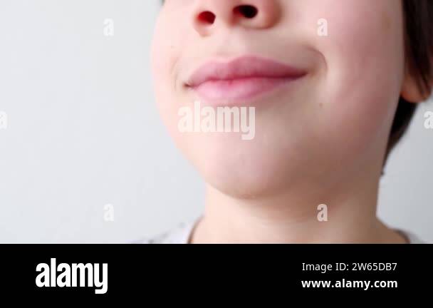 small child, kid performs articulation exercises for mouth, rolls the tongue into a tube, oral ...