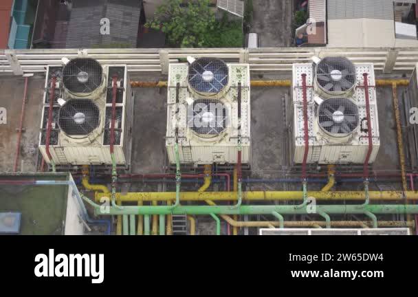 Footage of exhaust vents of industrial air conditioning and ventilation units on roof top ...
