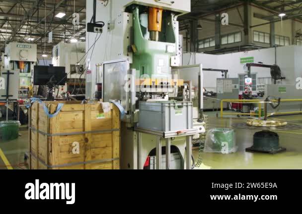 A large industrial punch press forming high precision metal parts for ...