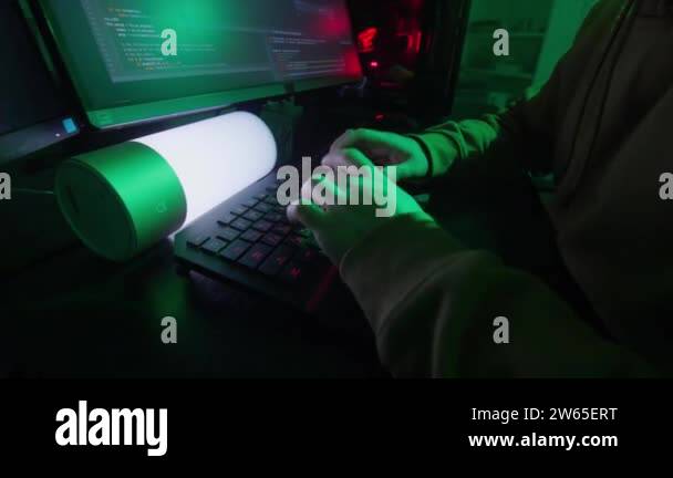 Anonymous person in a white mask works on the computer, inputs code ...