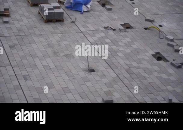 Process of construction of gray brick paved sidewalk, half built ...