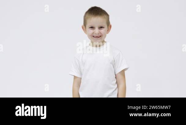 happy child boy in white t-shirt opening his mouth to show where he lost his baby teeths on ...