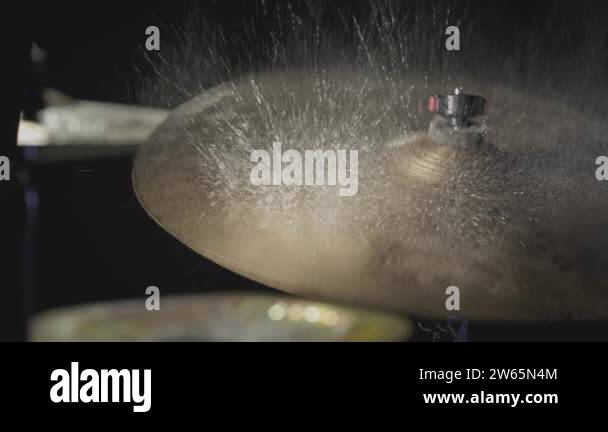 The drummer hits the wet drum cymbal with his drumstick and the water ...