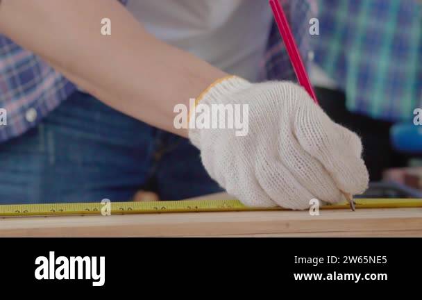 The carpenter is measuring and drawing. Carpenter using a red pencil to ...