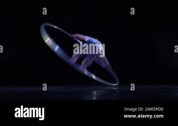 Circus artist shows concentration and balance while spinning on a Cyr ...