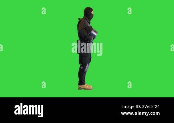 Riot policeman standing holding his helmet in hands on a Green Screen ...