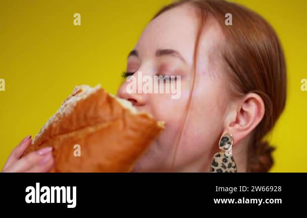 Close-up face of smiling redhead freckled woman biting and chewing ...