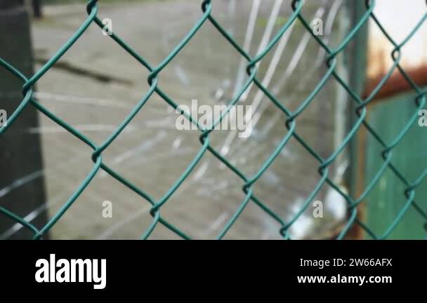 Fence mesh netting and broken glass window on a rusty iron wall. Cracks ...
