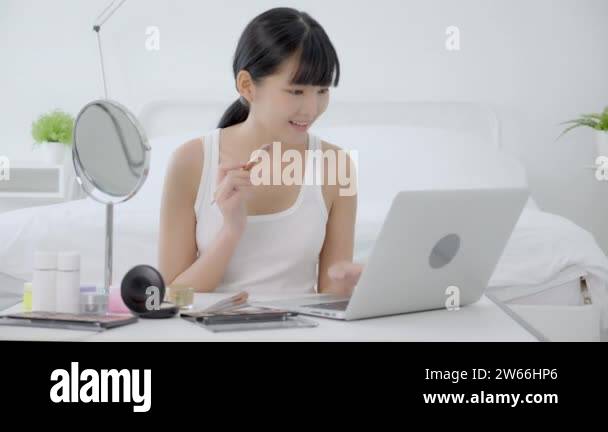 Beauty of young asian woman with learning makeup with brush on cheek on ...