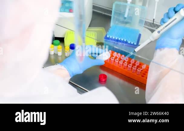 female PCR laboratory researcher in a protective medical suit, sterile ...
