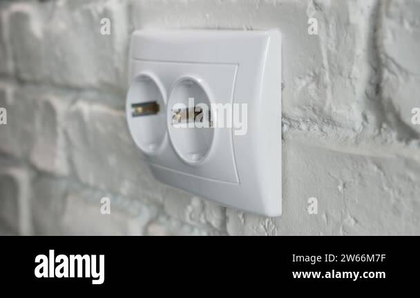 Plugging in an Electrical Power Cord with Plug to a Wall Socket in the ...