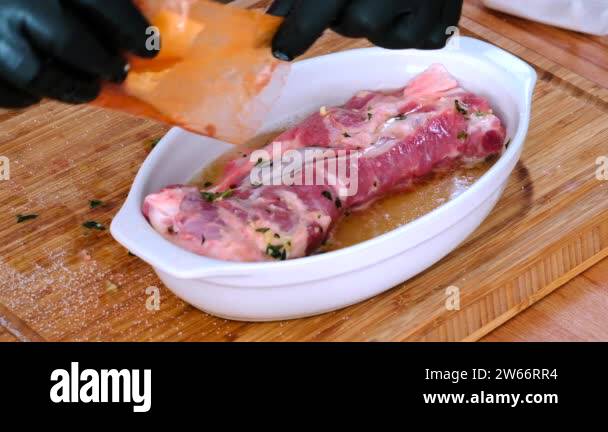 Close up view male chef hands cooking meat in the kitchen, pouring red ...