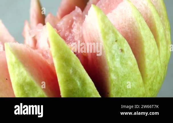 4K macro close up organic red guava juice and sliced guava rotating ...