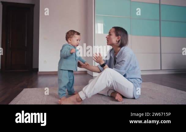 Lovely caucasian baby biy learning to walk taking first step walk to ...