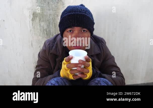 footage of a man sitting by the wall and his hands holding out with a ...
