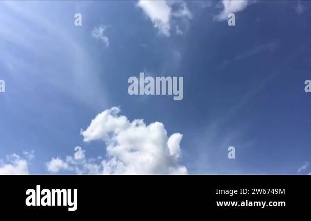 Time-lapse of blue sky with white rolling clouds from right to left ...