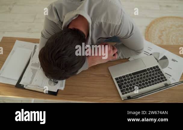 Businessman tired overworked he sleeping over a laptop computer on the ...