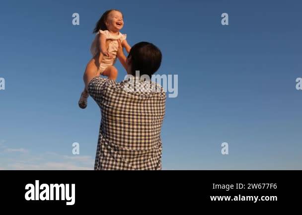 Child plays and wants to fly like an airplane. Dad throws his happy ...