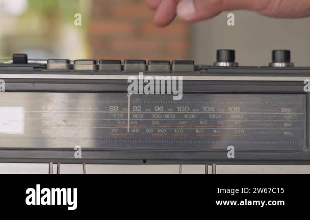 Man's finger presses a button to play an old obsoleted portable ...