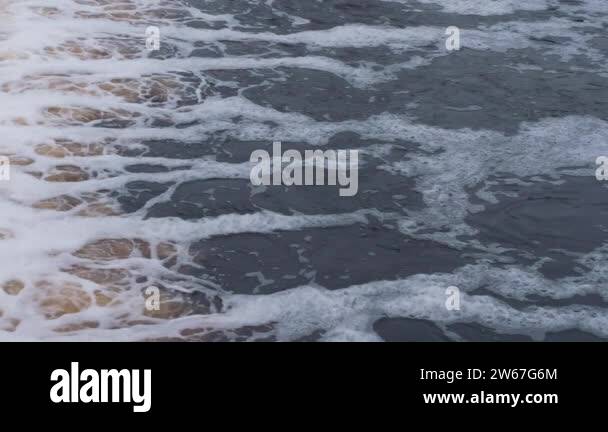 Slow Flow of Foam Jets. Water falls from the river cascade, foams and ...