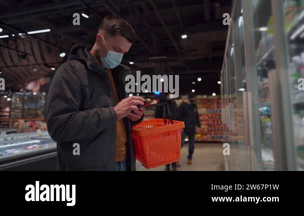 Man chooses groceries in store, walks with shopping basket, buys ...