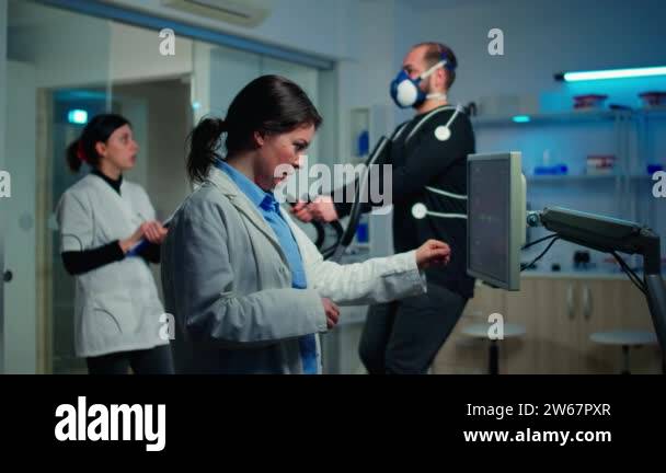 Doctor sport scientist checking EKG scan at monitor while man with mask running Stock Video ...