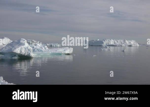 Arctic sailing among glaciers and floating ice blocks, in frozen sea ...