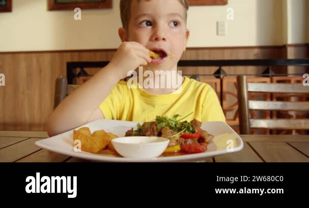 Cute healthy preschool boy eating potatoes and bell peppers,vegetables ...