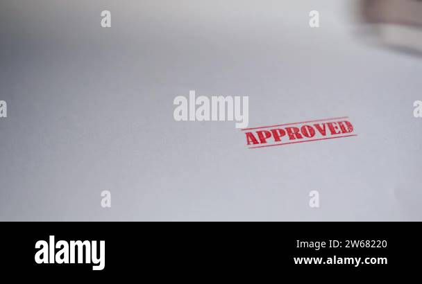 A stamp Approved is placed on a sheet of white paper, copyspace ...